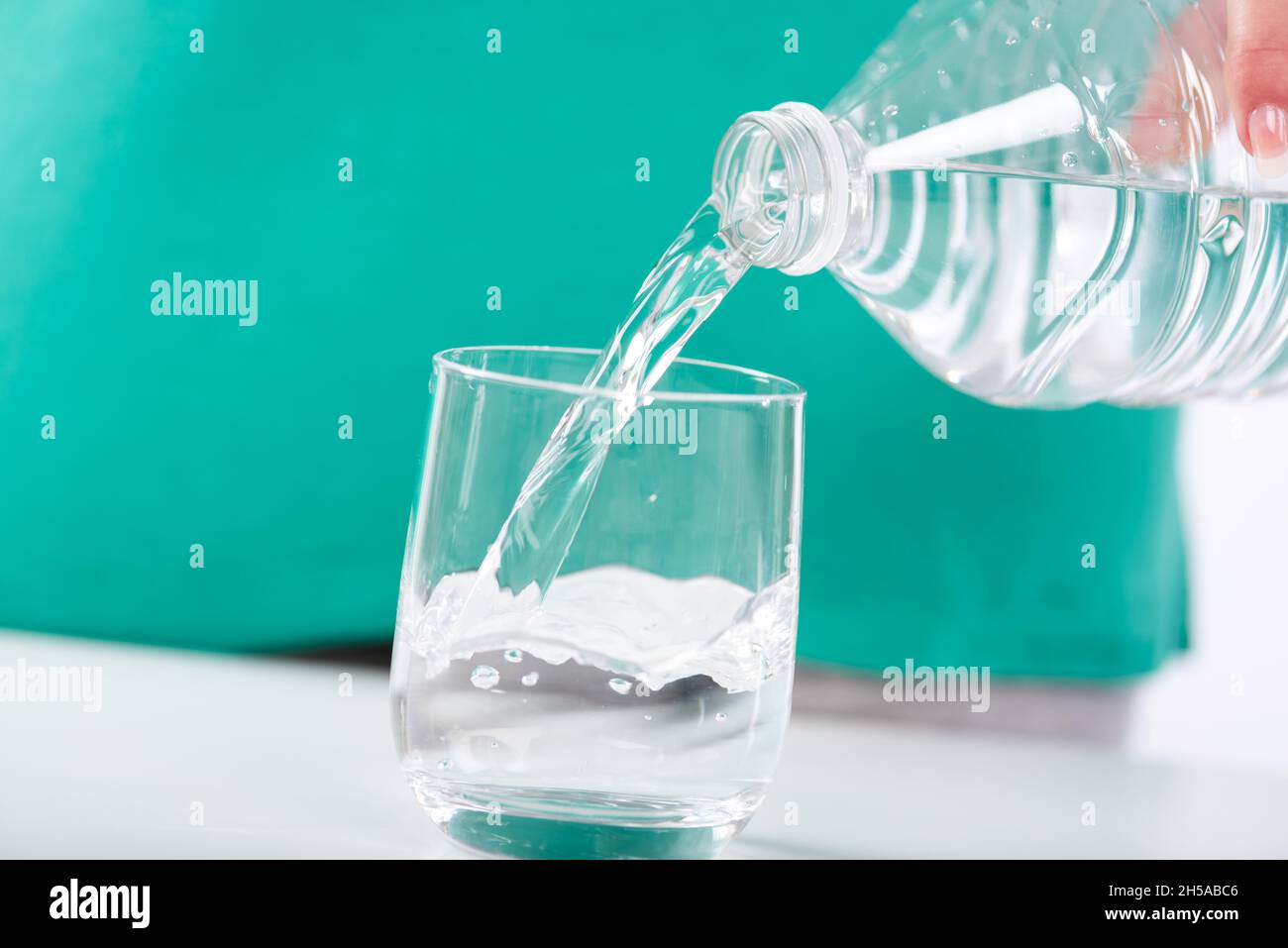 Pouring water from a bottle into a glass Stock Photo - Alamy