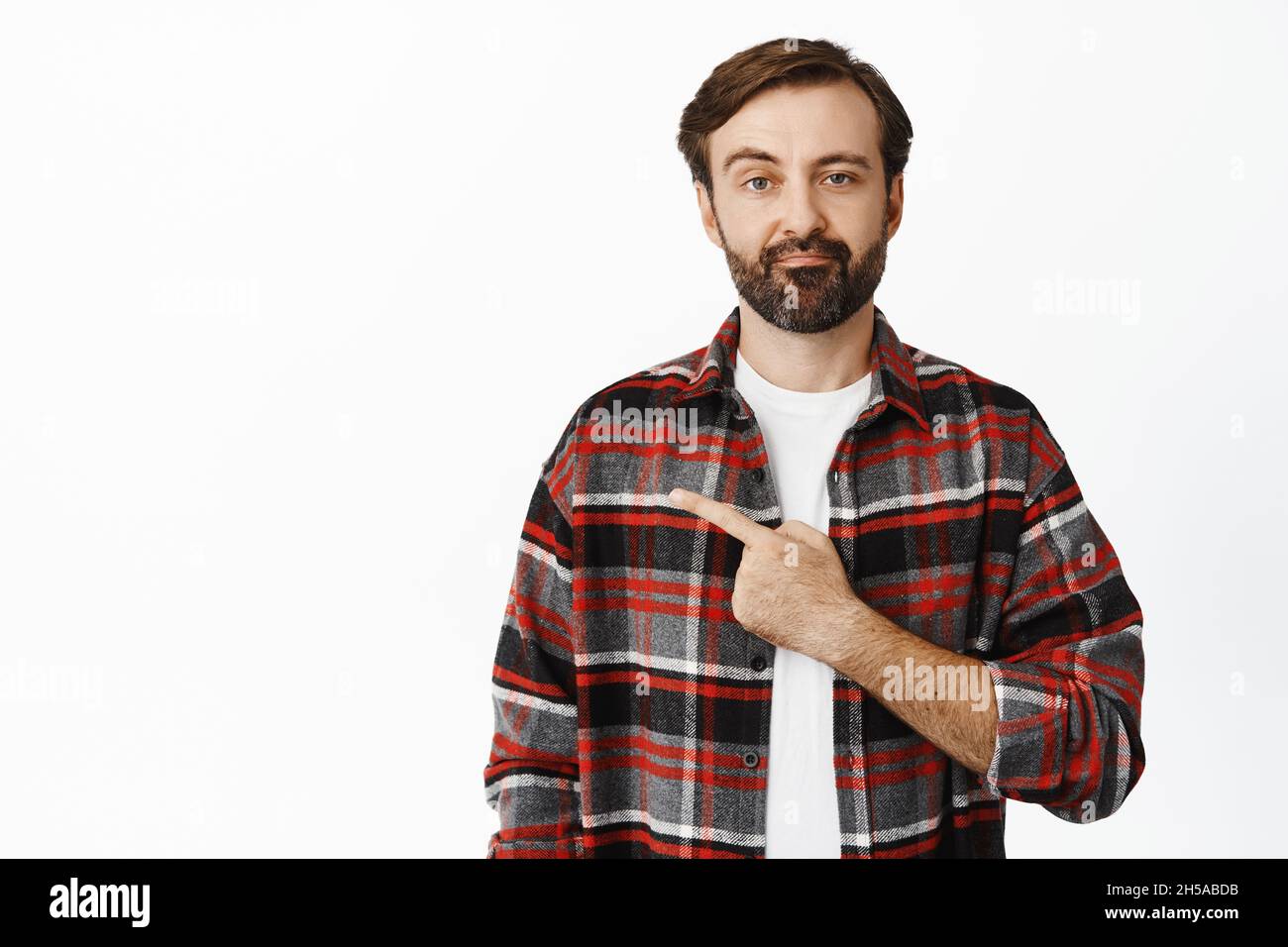 Disappointed adult guy with beard, pointing left and grimacing upset ...