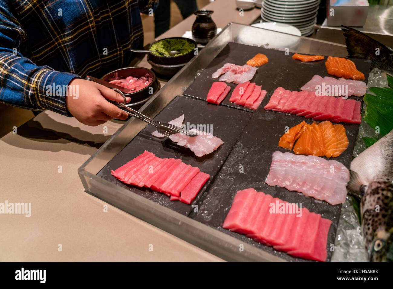 Girl hand picking Sashimi in Japanese buffet Stock Photo - Alamy