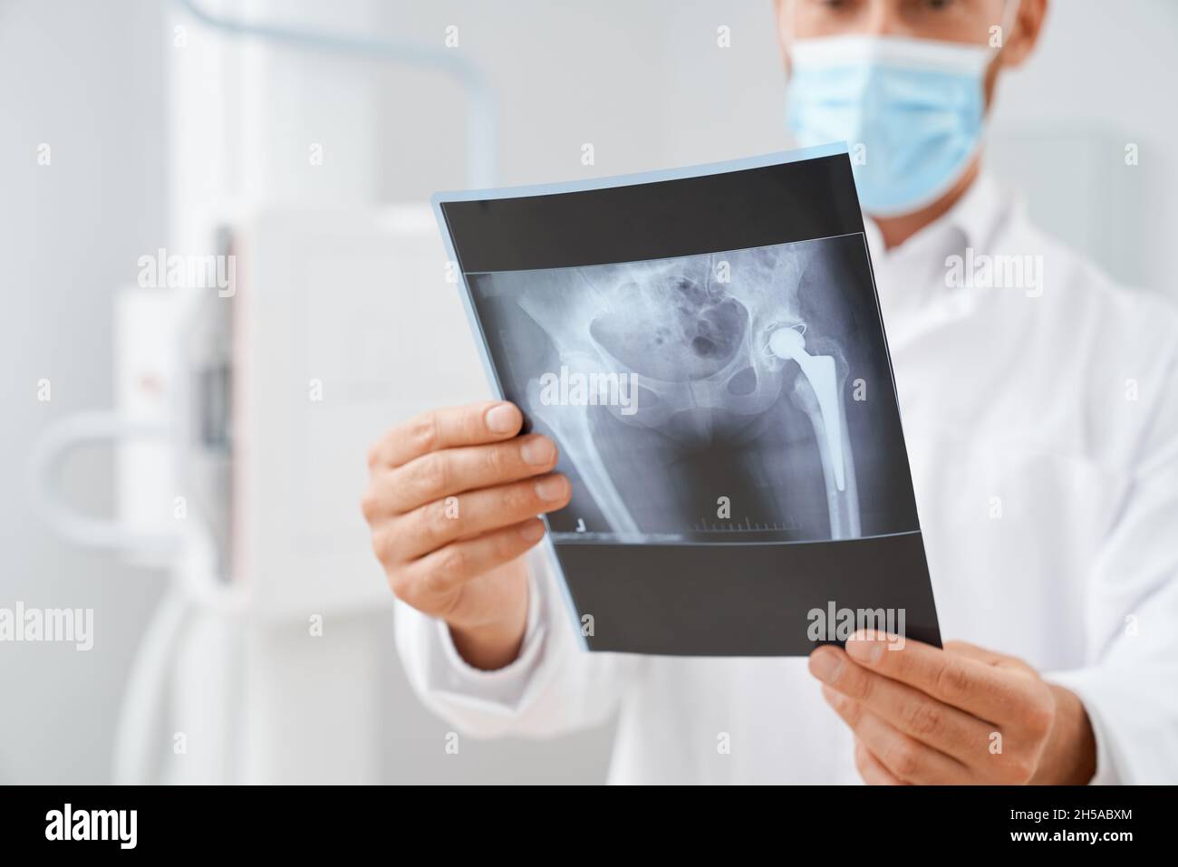 Close up of doctor wearing mask holding scan with result after ...