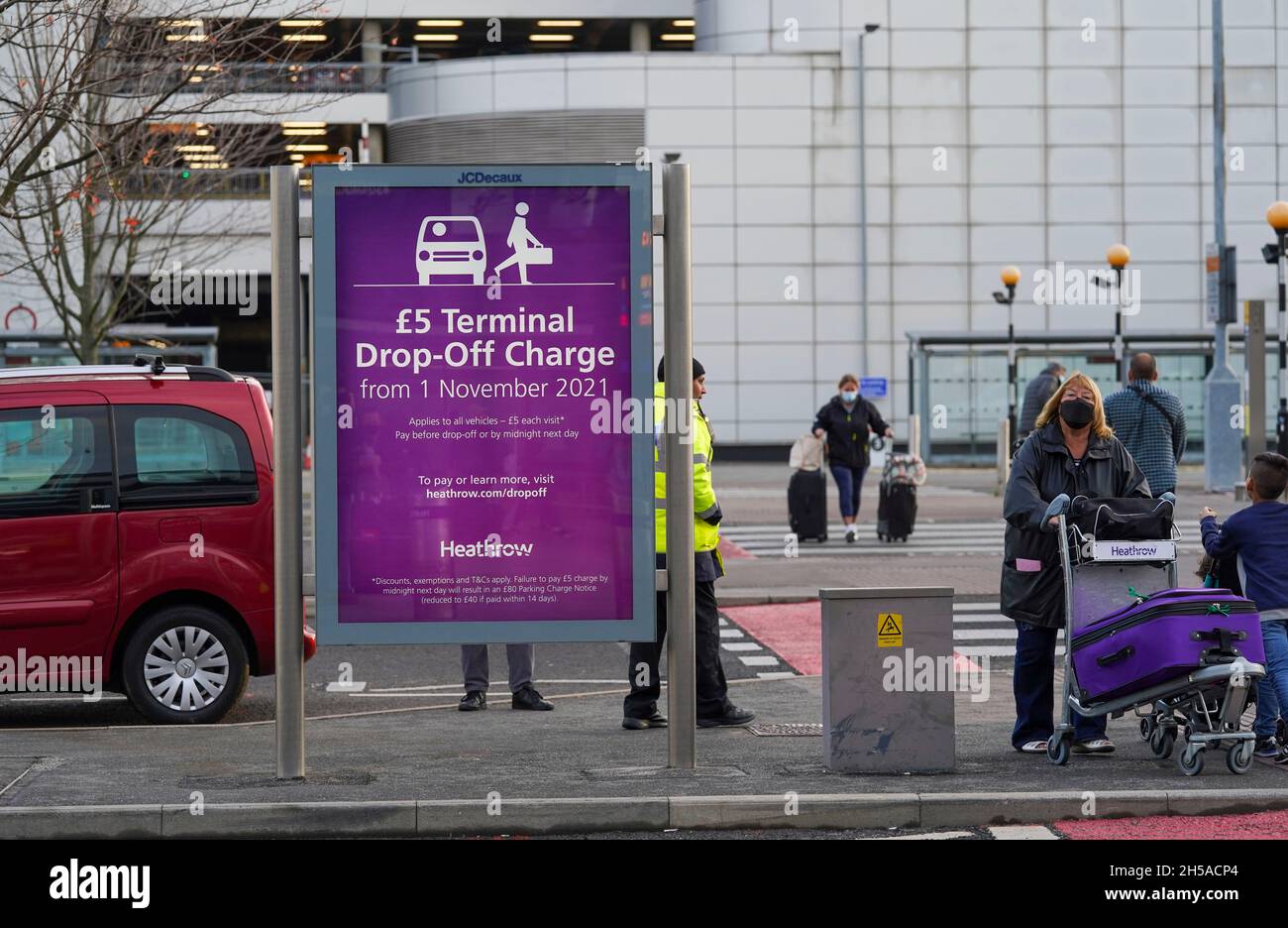 Passengers walk past an information sign at Terminal 3 of Heathrow ...