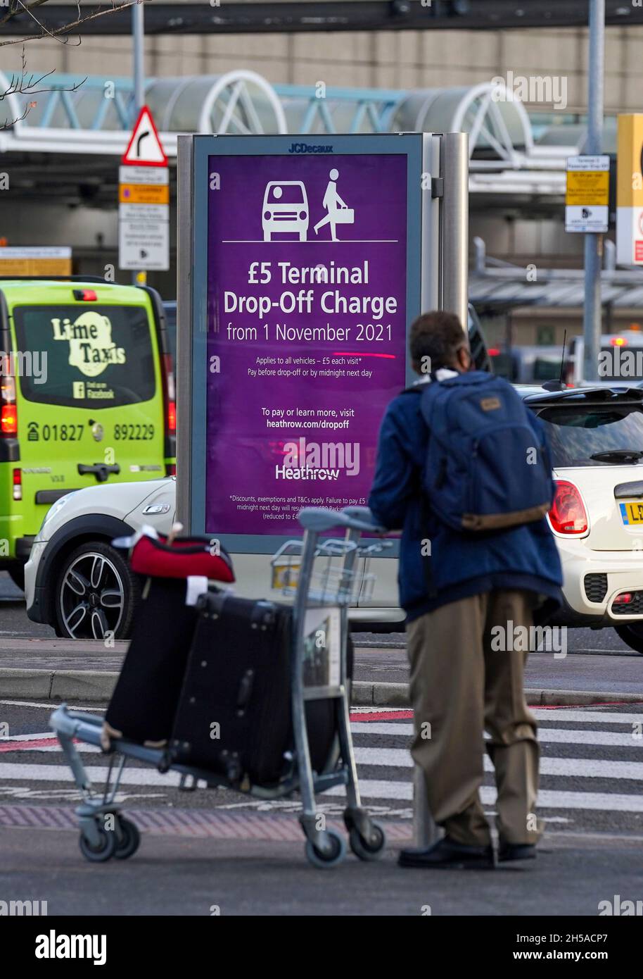 Passengers walk past an information sign at Terminal 3 of Heathrow ...