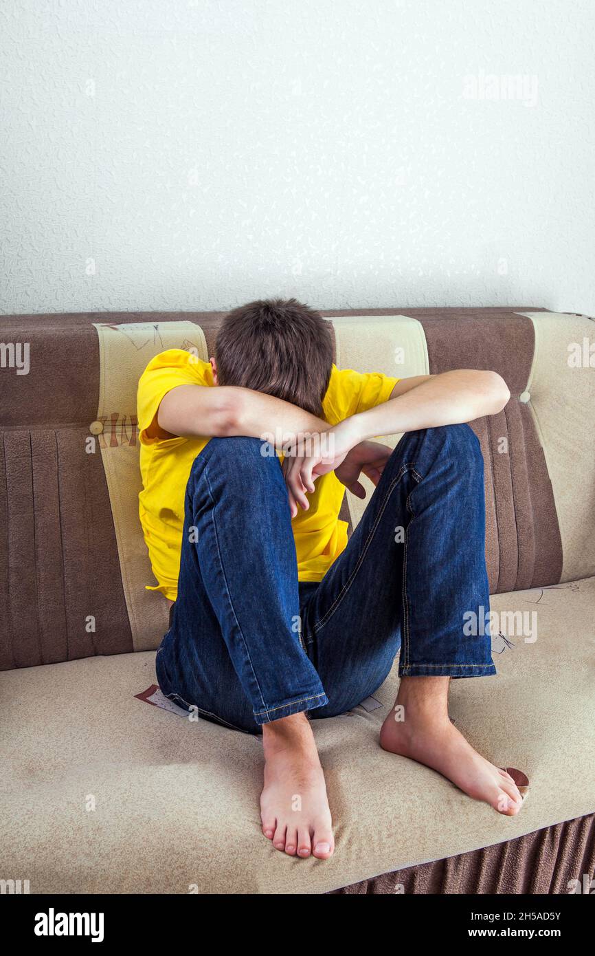 Sad Young Man on the Sofa hide the Face and Crying Stock Photo - Alamy