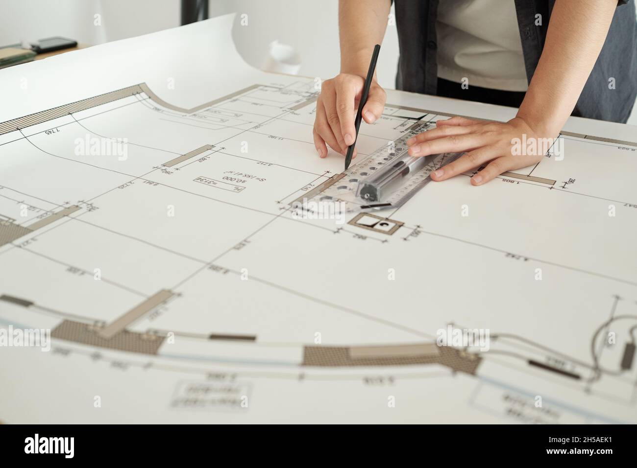 Hands of young female engineer with ruler and pencil drawing sketch of ...