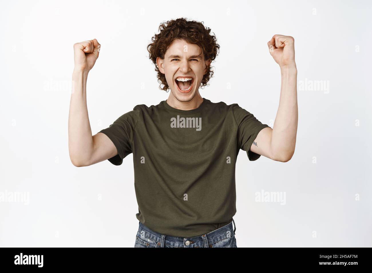 Enthusiastic young man shouting, chanting and celebrating triumph ...