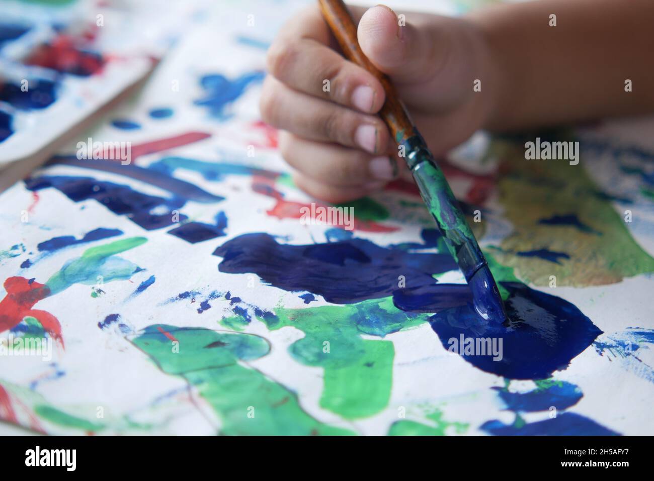 child hand drawing with art brush on a paper Stock Photo - Alamy