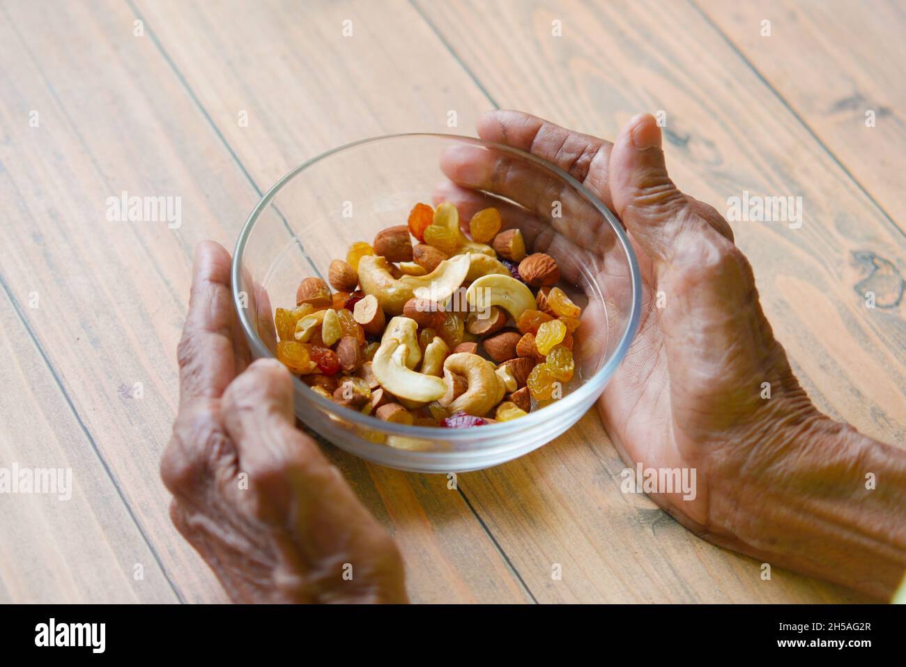 senior women hand hold a bowl of many mixed nuts Stock Photo - Alamy