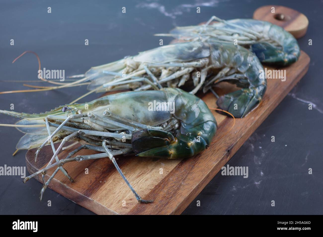 close up of king prawn on a chopping board on table Stock Photo - Alamy