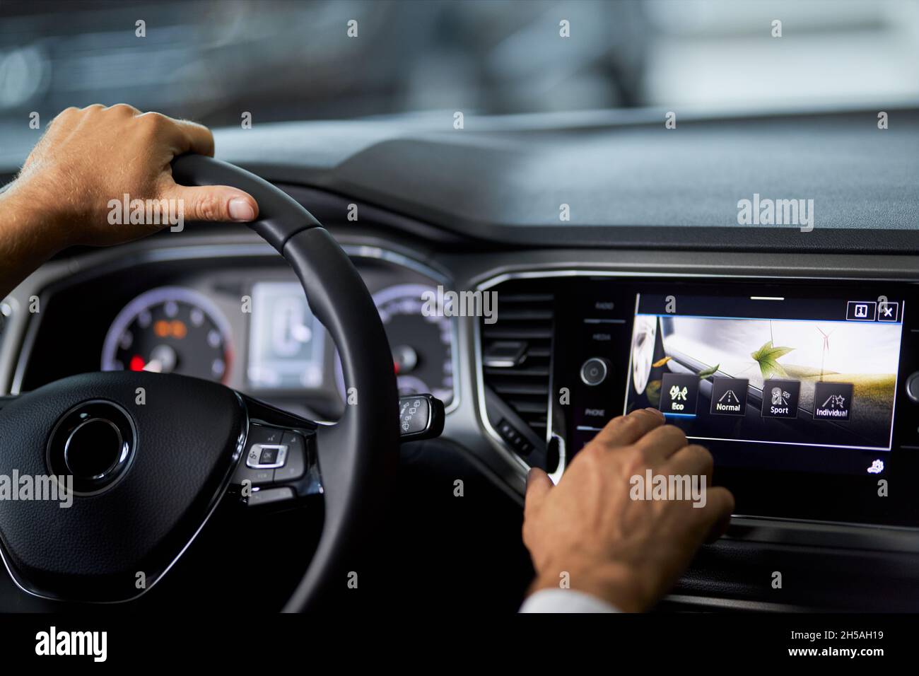 Close up of man touching multimedia screen of luxury car while sitting ...