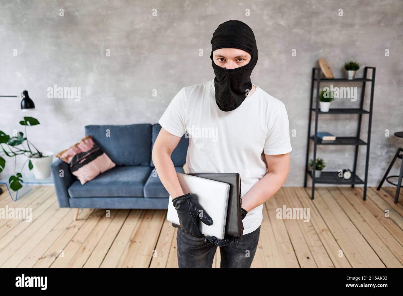 Thief with black balaclava stealing modern expensive television. Masked ...