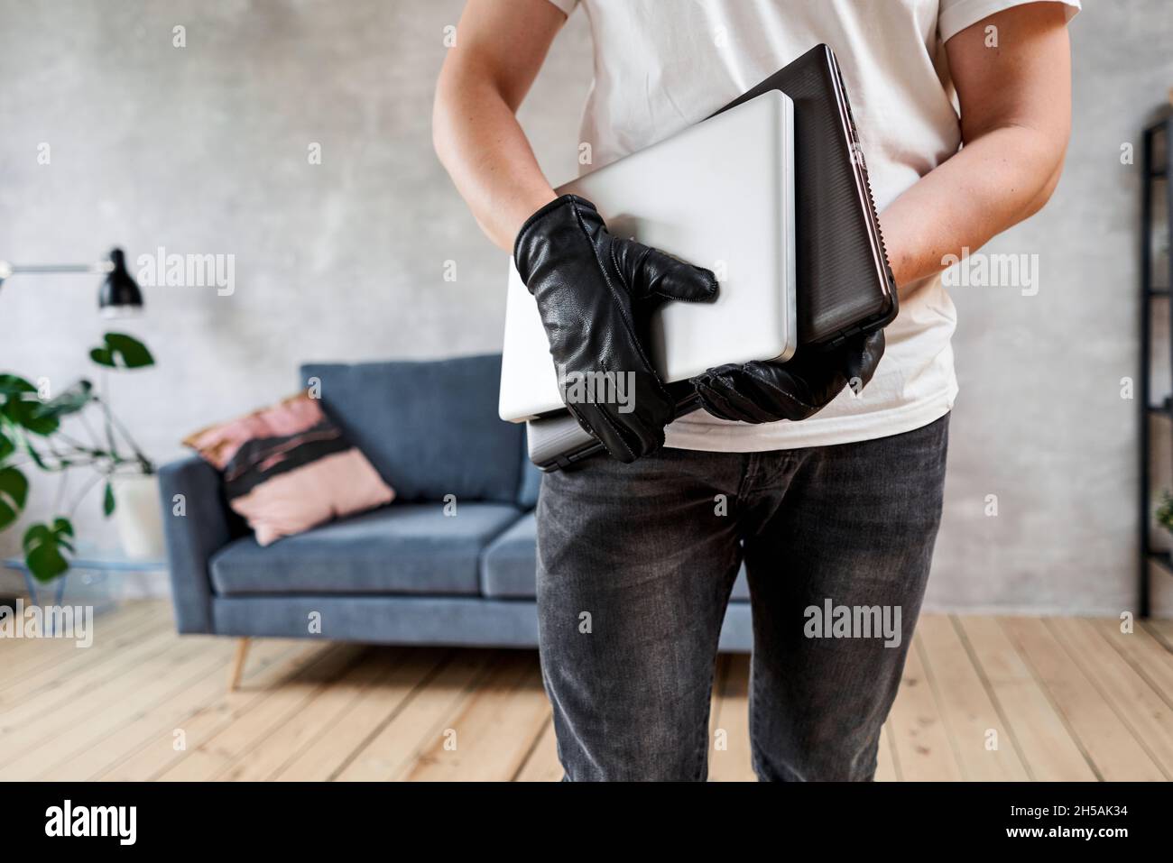 Thief with black balaclava stealing modern expensive television. Masked ...