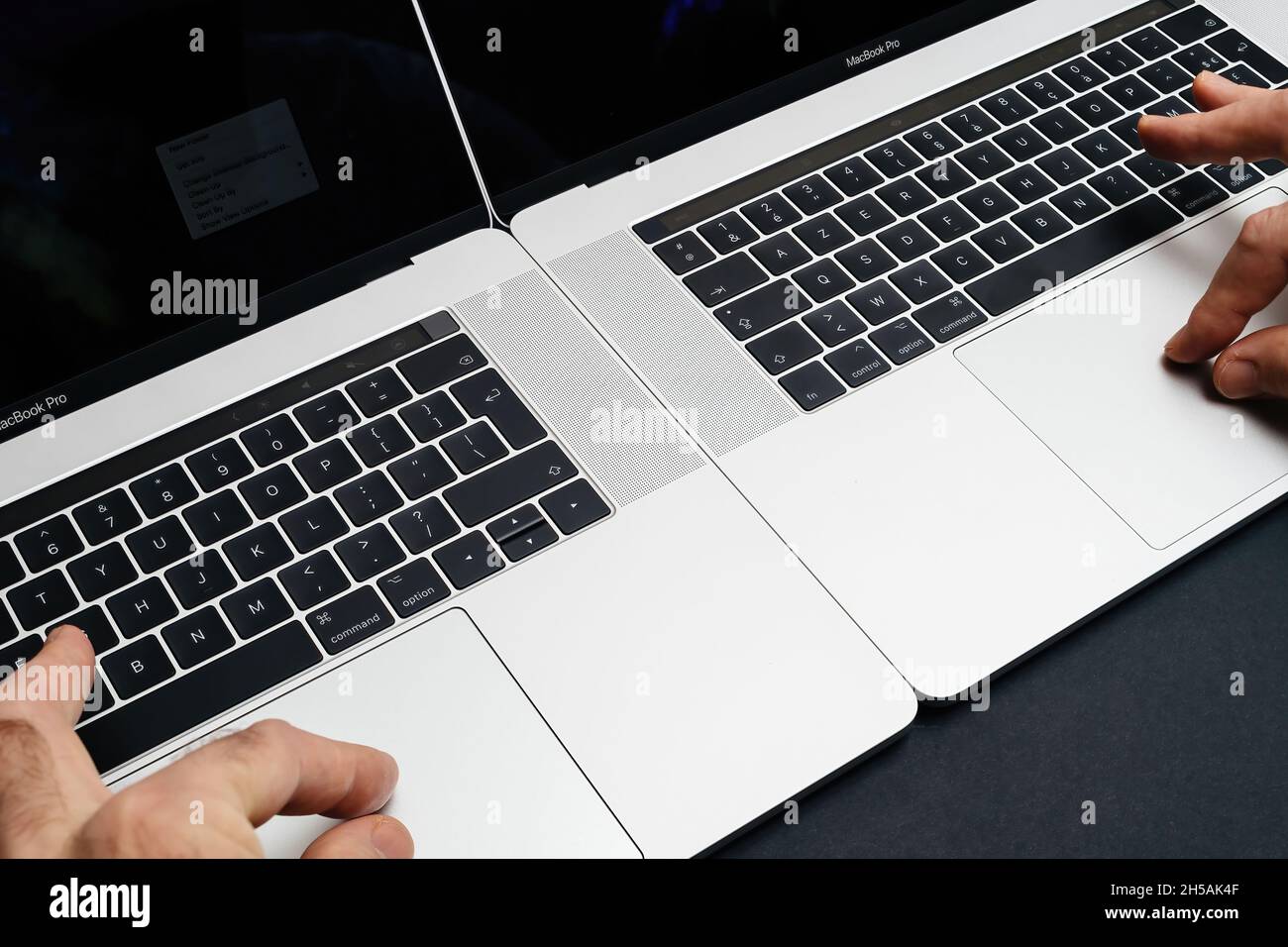 Male hand operating two laptop simultaneously professional Apple ...