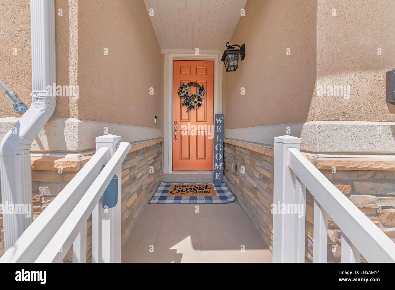Stylish bronze front door exterior with wreath and welcome board ...
