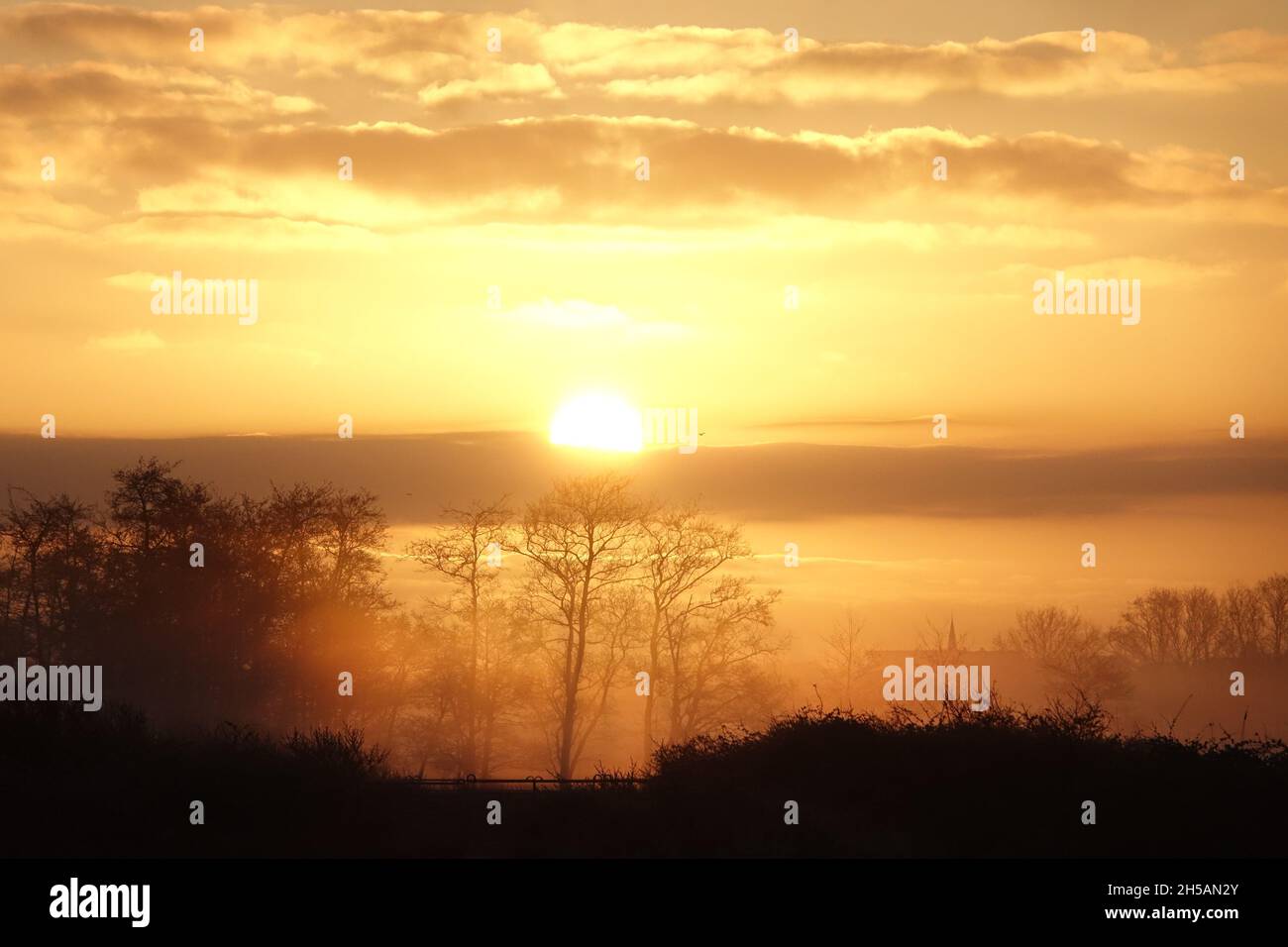 sunrise with clouds and mist Stock Photo - Alamy