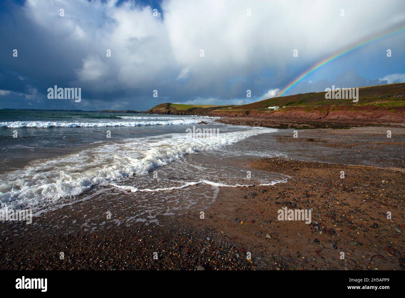 Manorbier beach Pembrokeshire Wales UK with rainbow ending at white ...