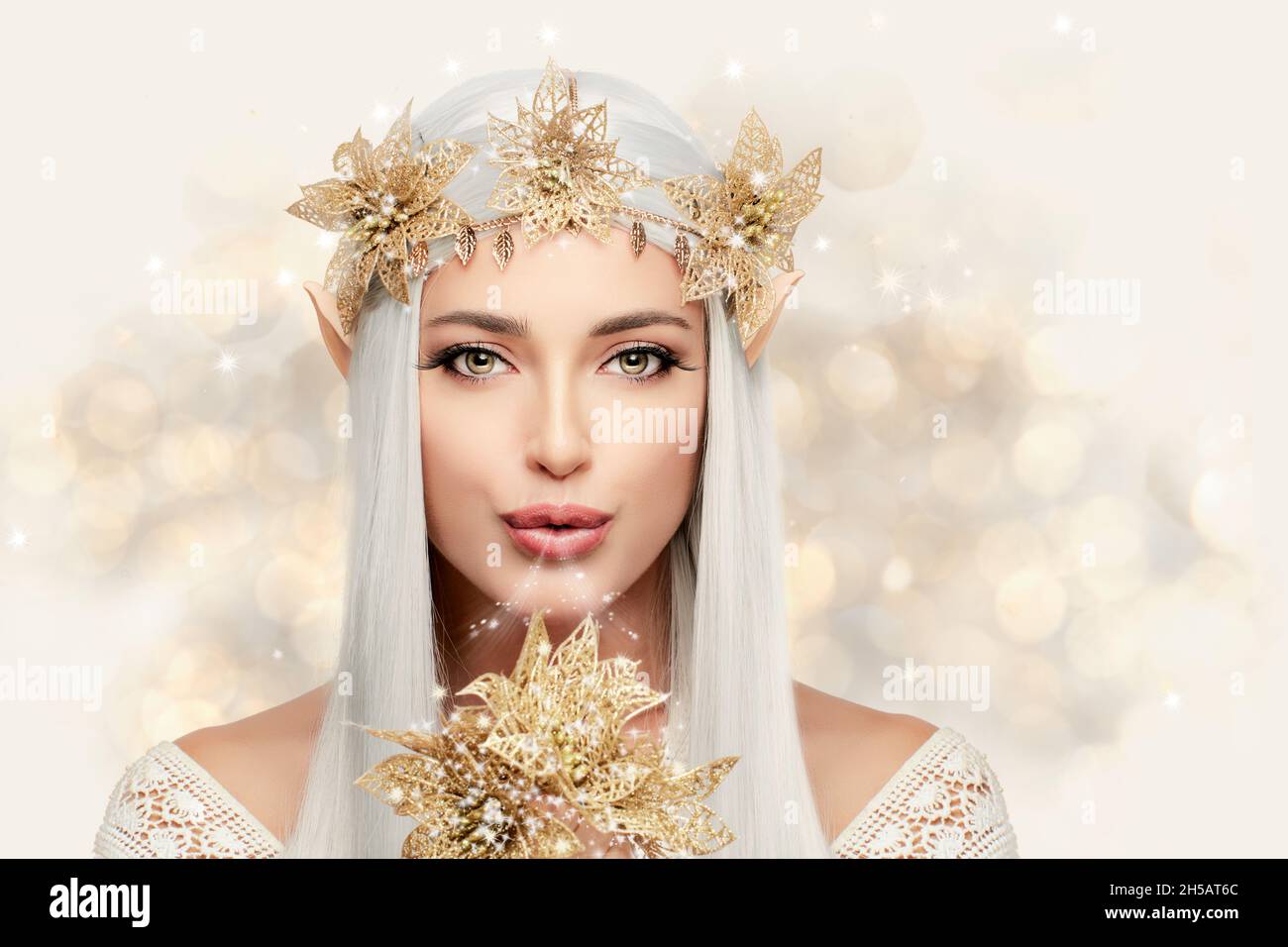 Attractive elf queen with golden flowers looking at camera while ...