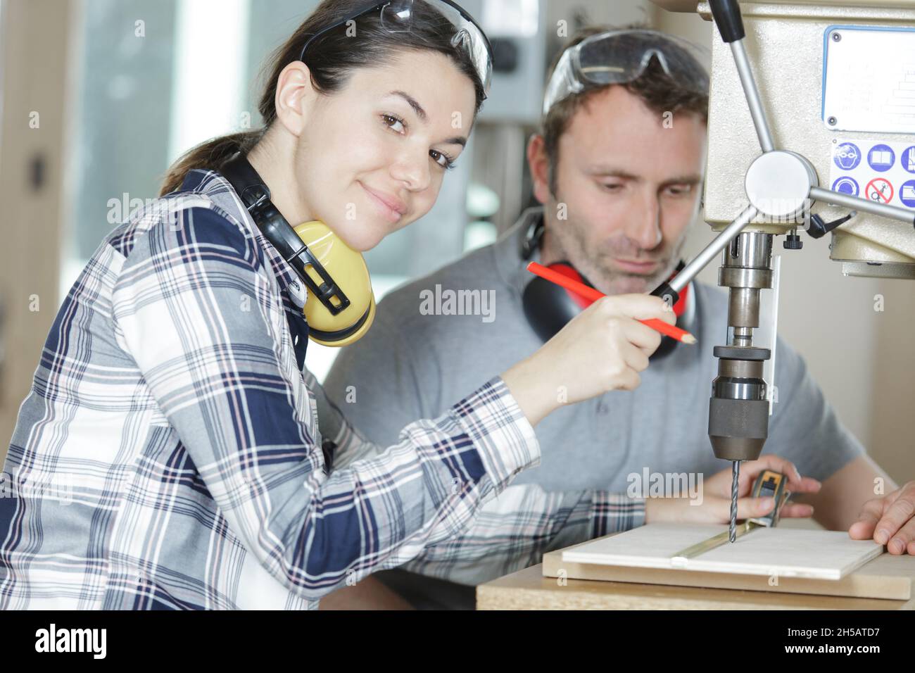 content woman and man using drill machine Stock Photo - Alamy