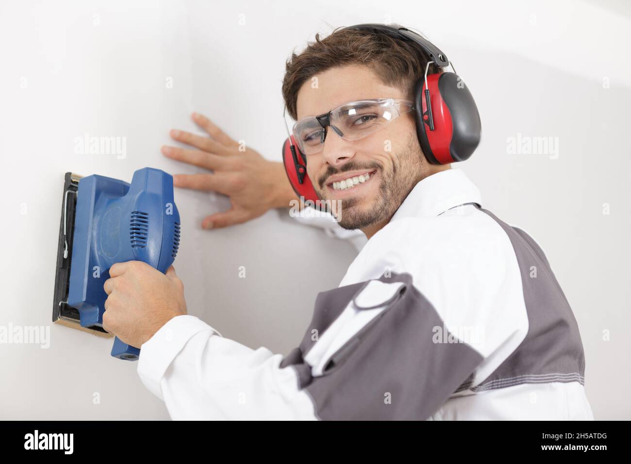 professional construction worker using sander on interior wall Stock ...