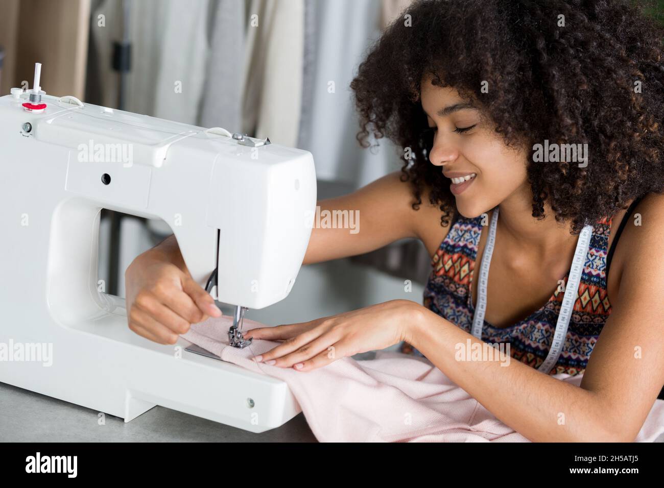 beautiful smiling tailor enjoying work on sewing machine Stock Photo ...