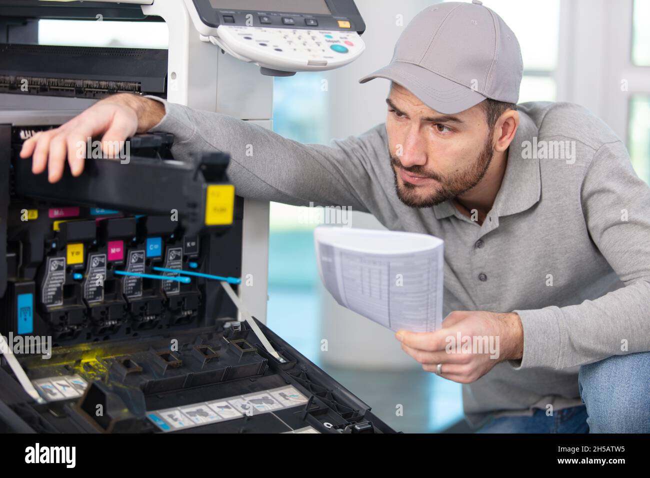 young male technician repairing digital photocopier machine Stock Photo ...