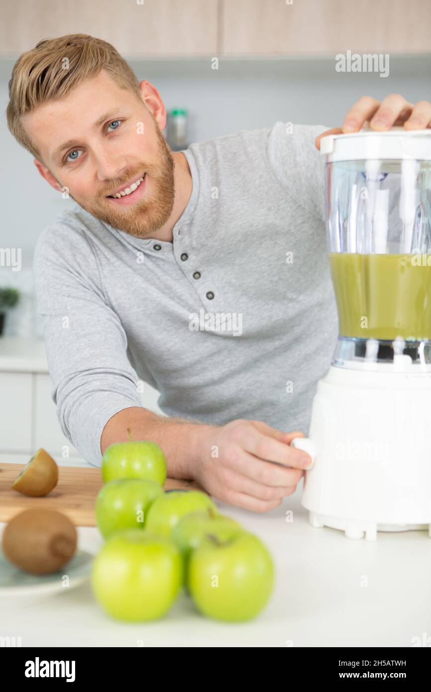 a young man is making juice from a juicer Stock Photo - Alamy