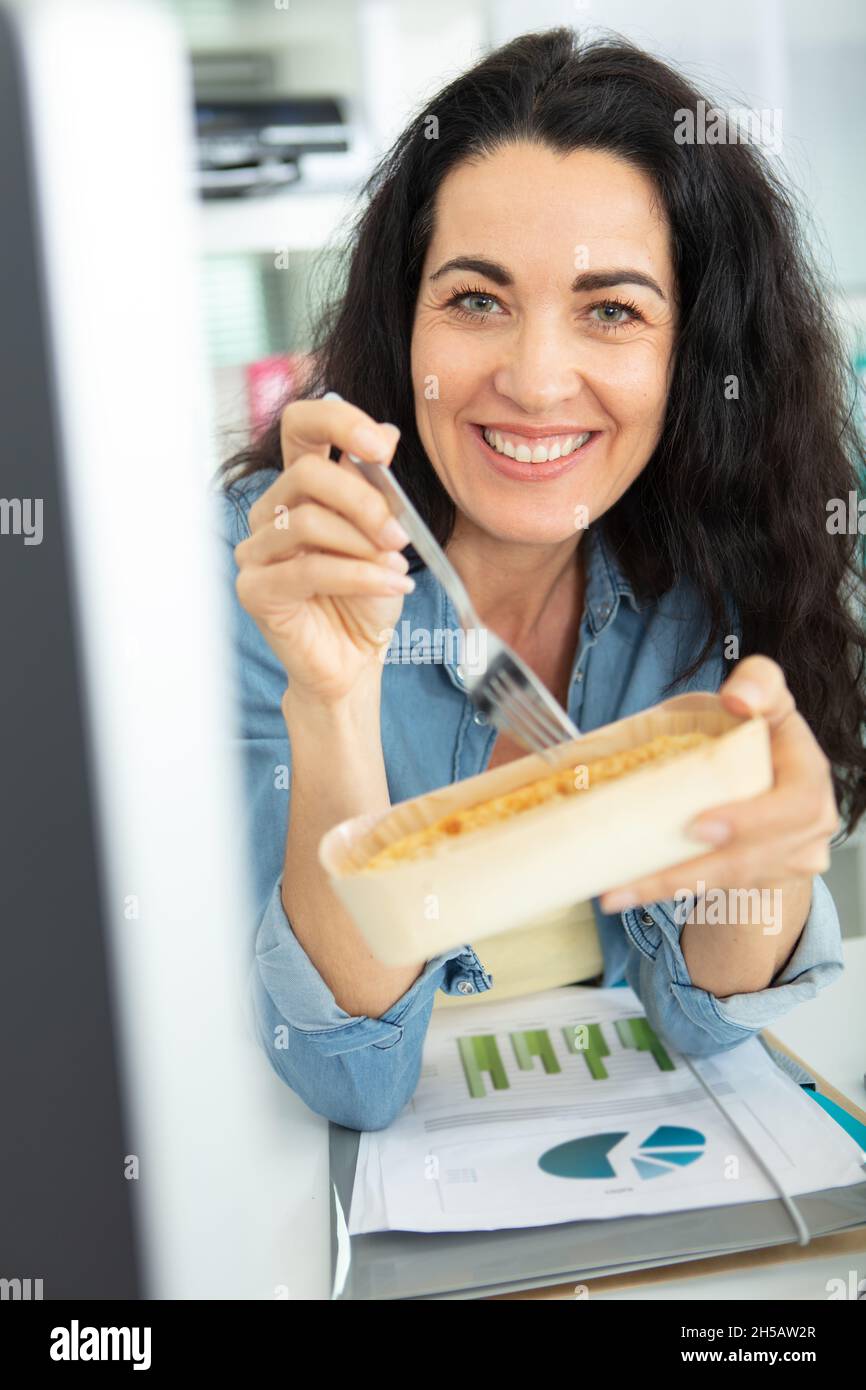 business woman eating lunch in her office while working Stock Photo - Alamy