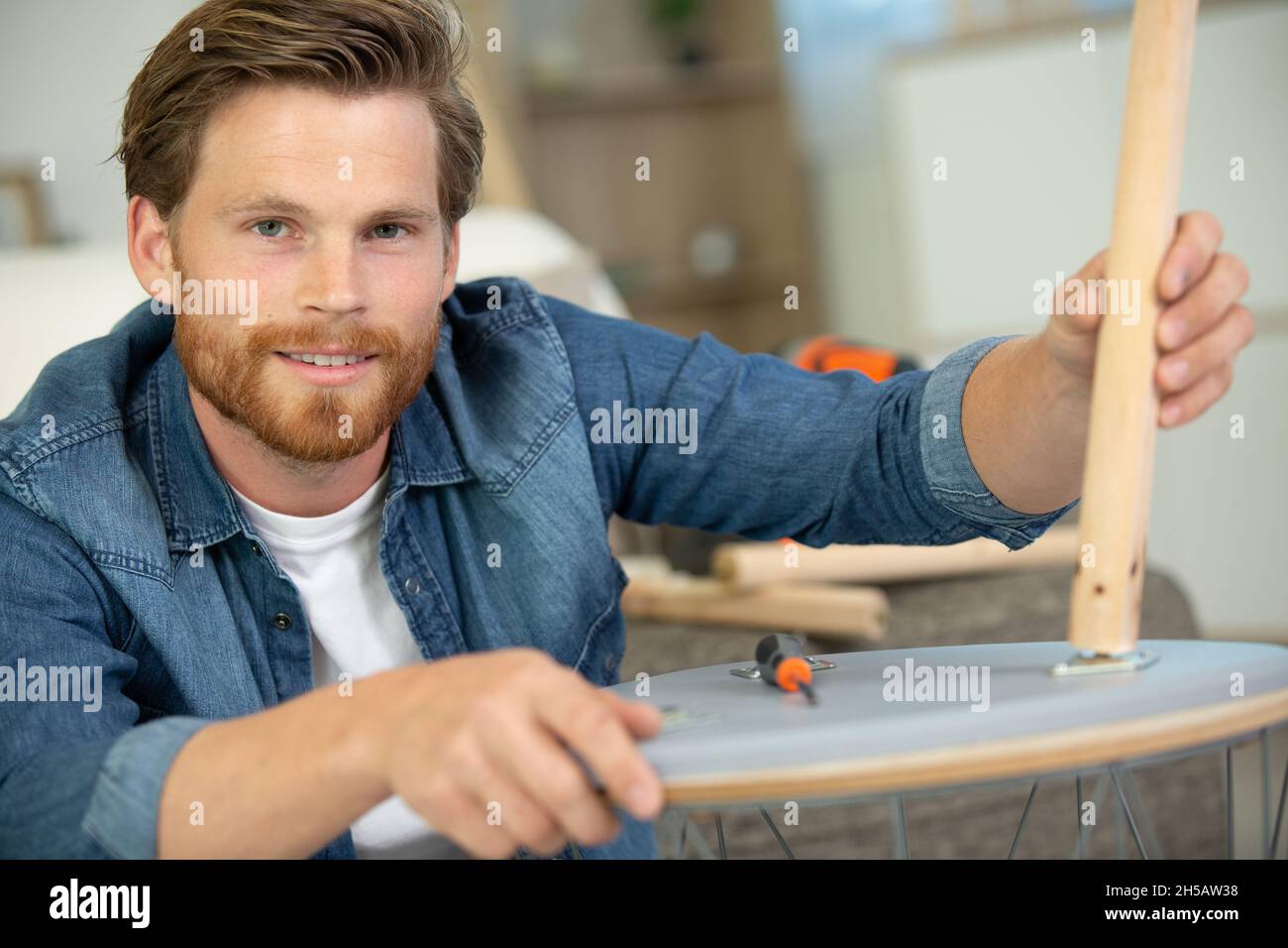 the young man tries himself to fold his stools Stock Photo - Alamy