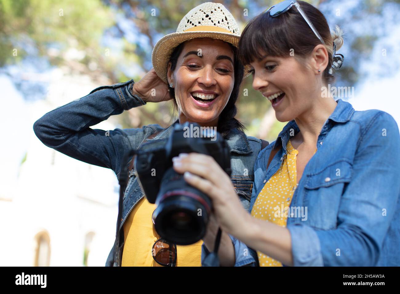 young woman showing pictures to her friend Stock Photo - Alamy