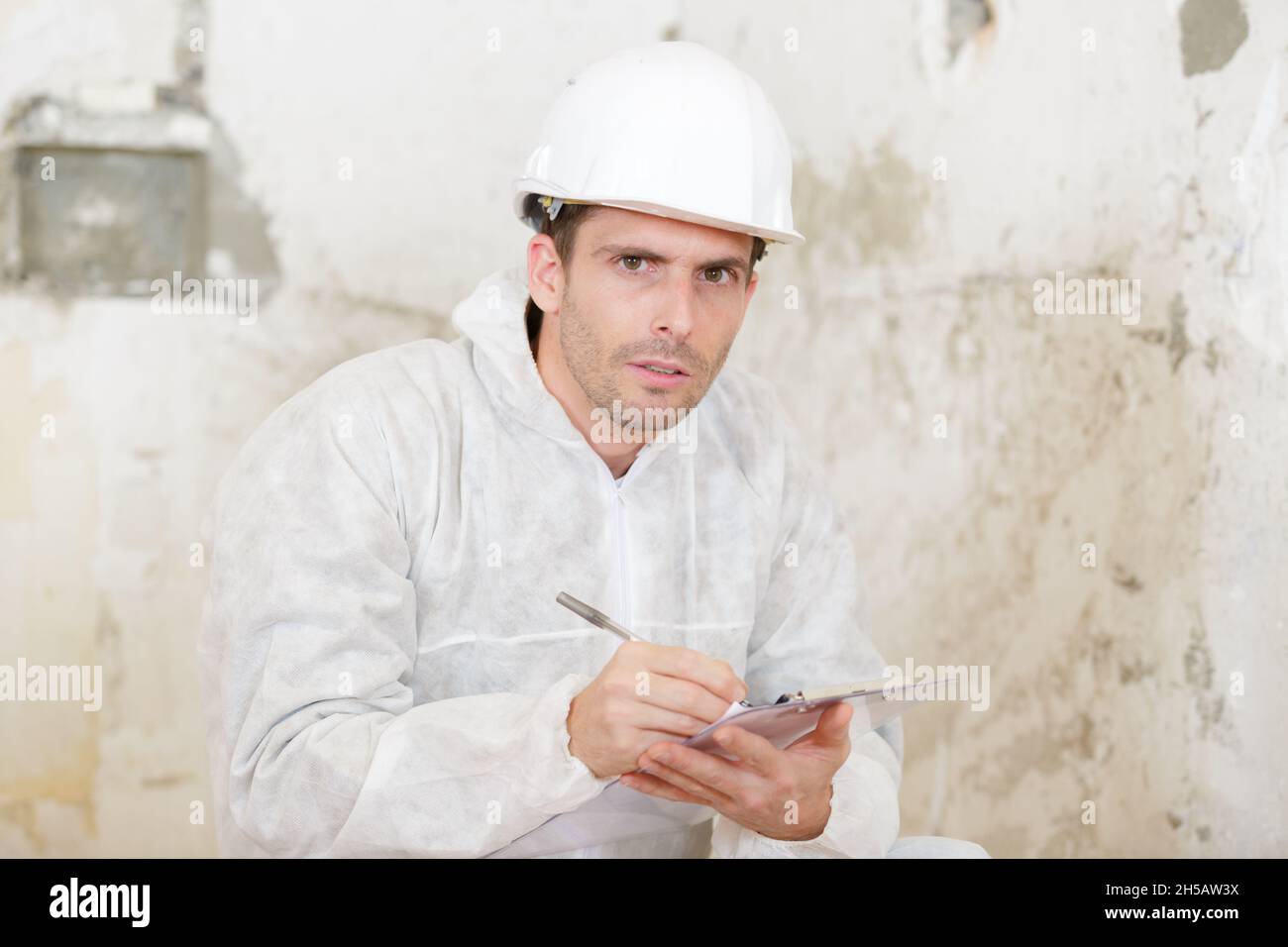 male builder writing on clipboard Stock Photo - Alamy