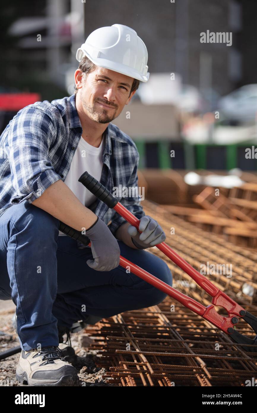 construction worker using pliers on metal tray Stock Photo - Alamy