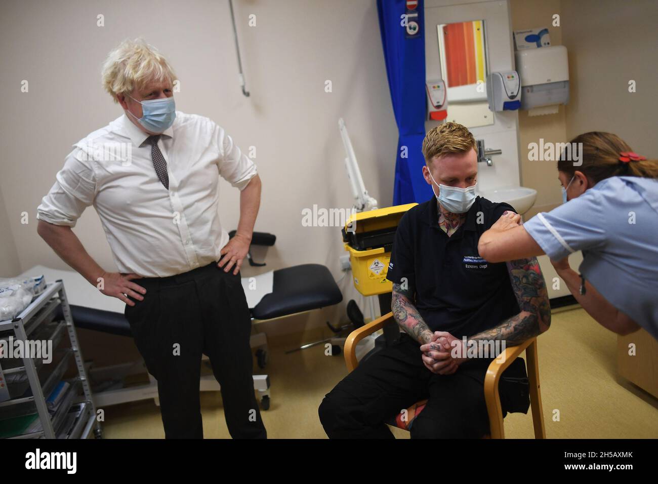 Prime Minister Boris Johnson watches as nurse Sandra Guy gives a COVID ...