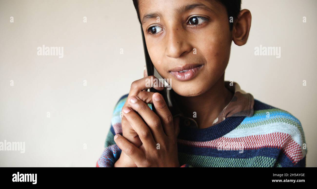 Portrait of a young boy from India talking on the phone Stock Photo - Alamy