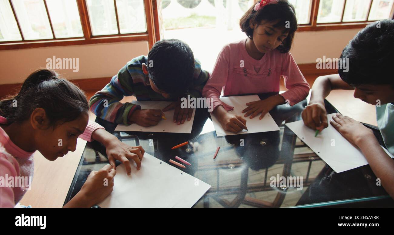 Group of south Asian kids drawing with colorful pencils Stock Photo - Alamy