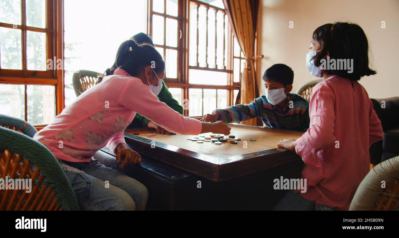 Children with masks playing at home Stock Photo - Alamy