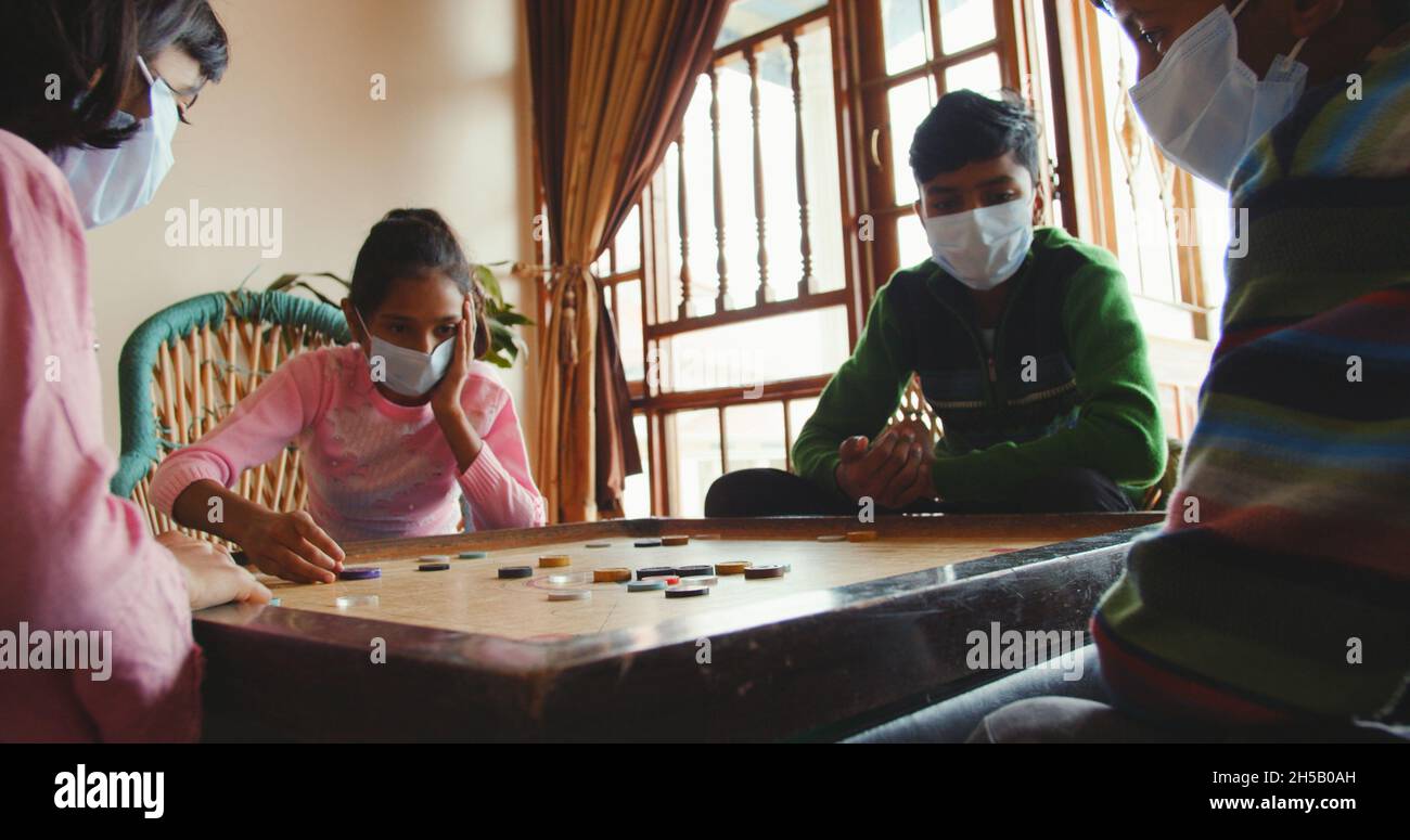 Children with masks playing at home Stock Photo - Alamy