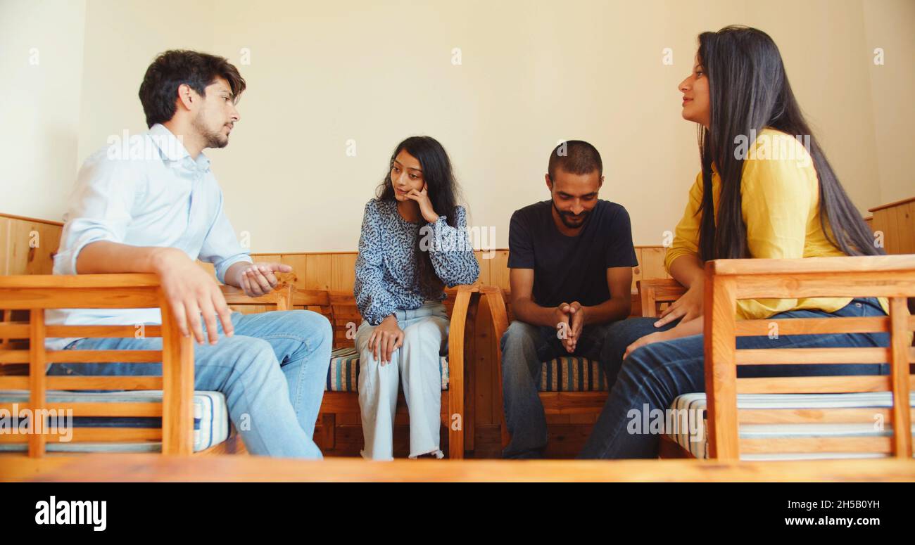 Portrait of young friends from india having a conversation at home in ...