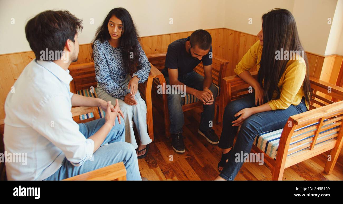 Portrait of young friends from india having a conversation at home in ...