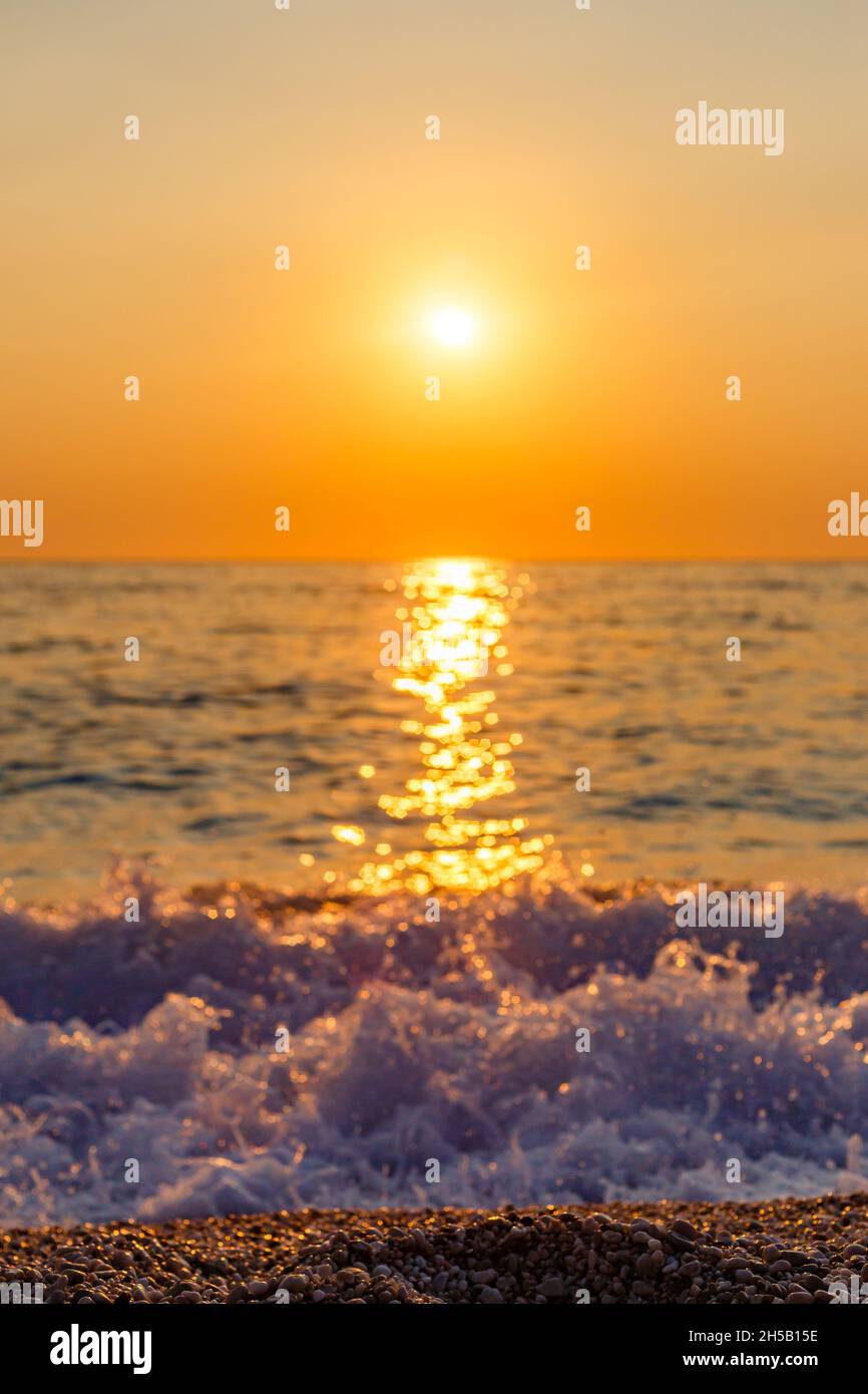 Vertical shot of a gorgeous sunset at Lefkada, Greece with a golden sun ...