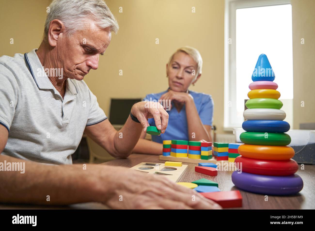 Mature man while recovery of motor skills in rehabilitation center ...