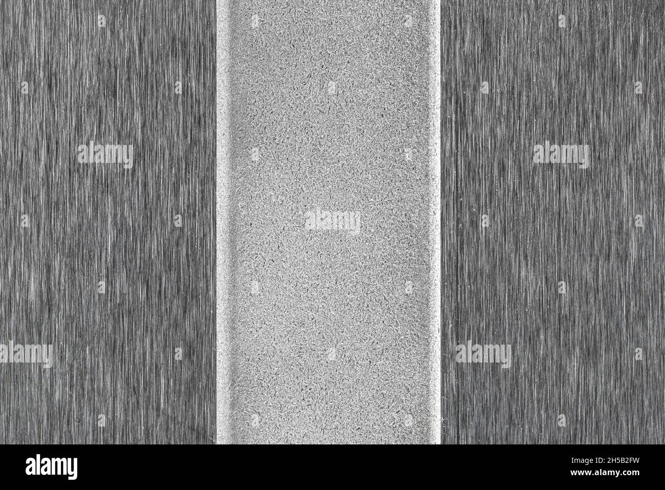 Background made from a macro photo of a rough and smooth metal surface ...