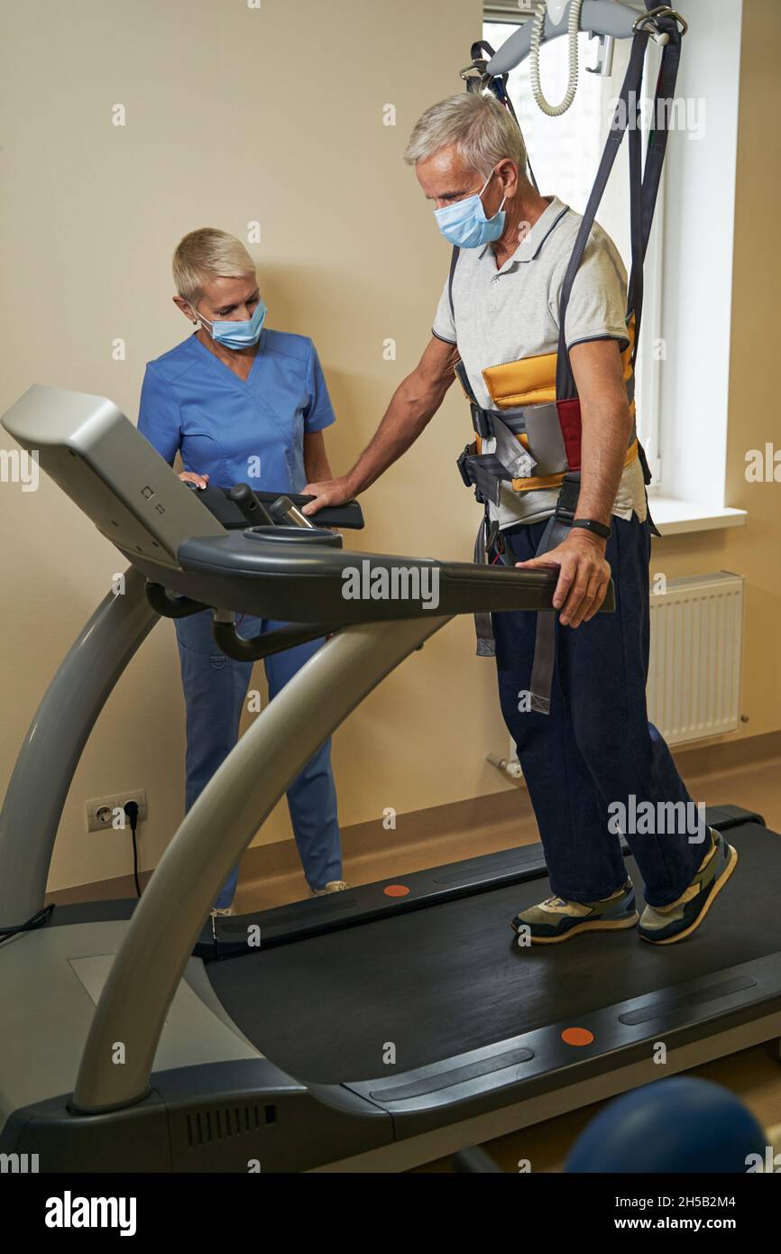 Mature patient doing exercises during rehabilitation in medical center ...
