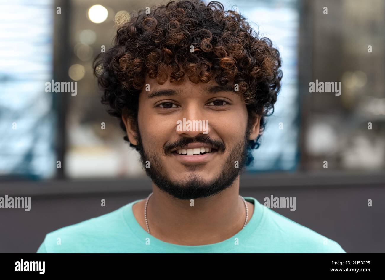 Face smiling portrait of young Indian man student looking at camera ...