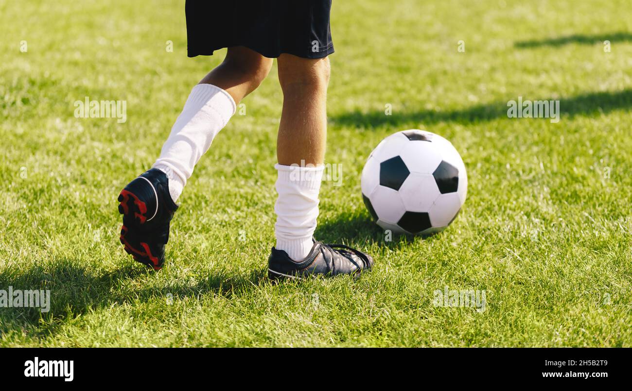 Football Running With Ball on Fresh Grass Field. Boy in Cleats Kicking ...
