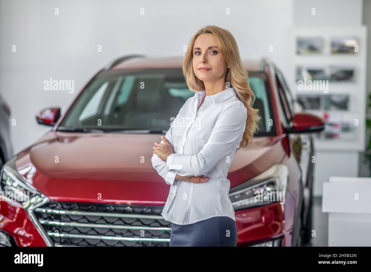 Blonde business woman in car dealership Stock Photo - Alamy