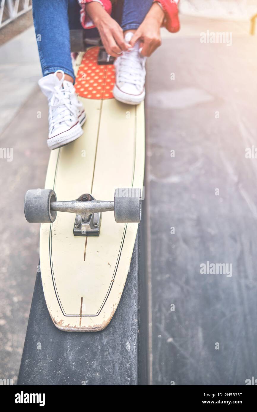 Skater girl getting ready for action, tying shoestring. First step ...