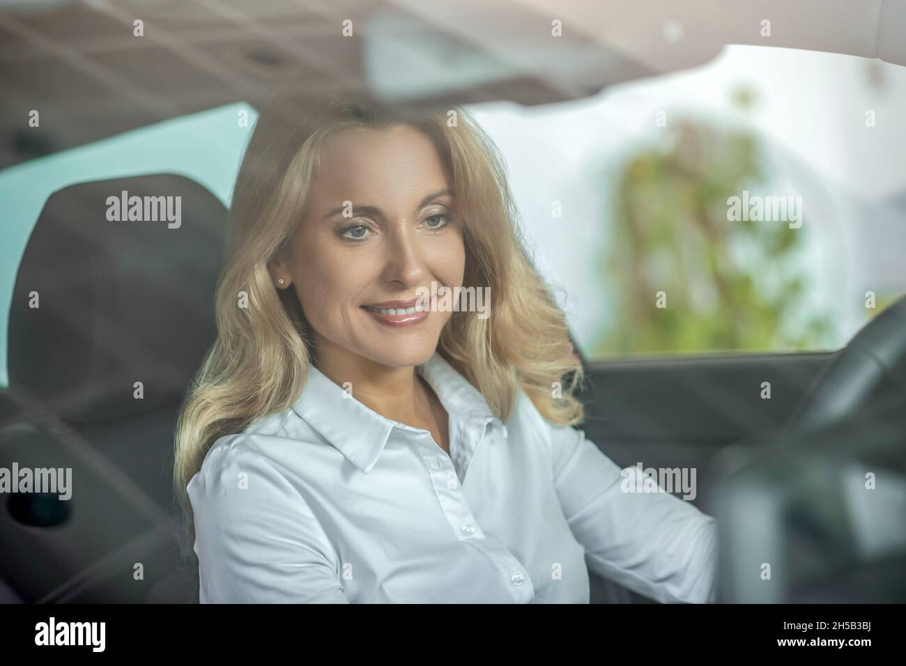 Joyful pretty woman driving in car Stock Photo - Alamy