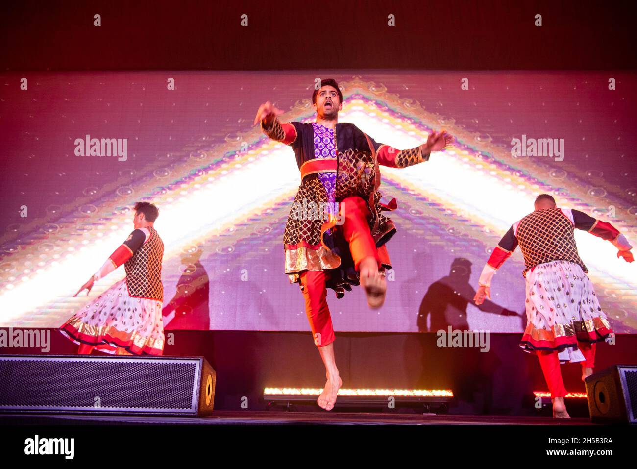 Performers dancing on stage with bodies creating silhouette shapes ...
