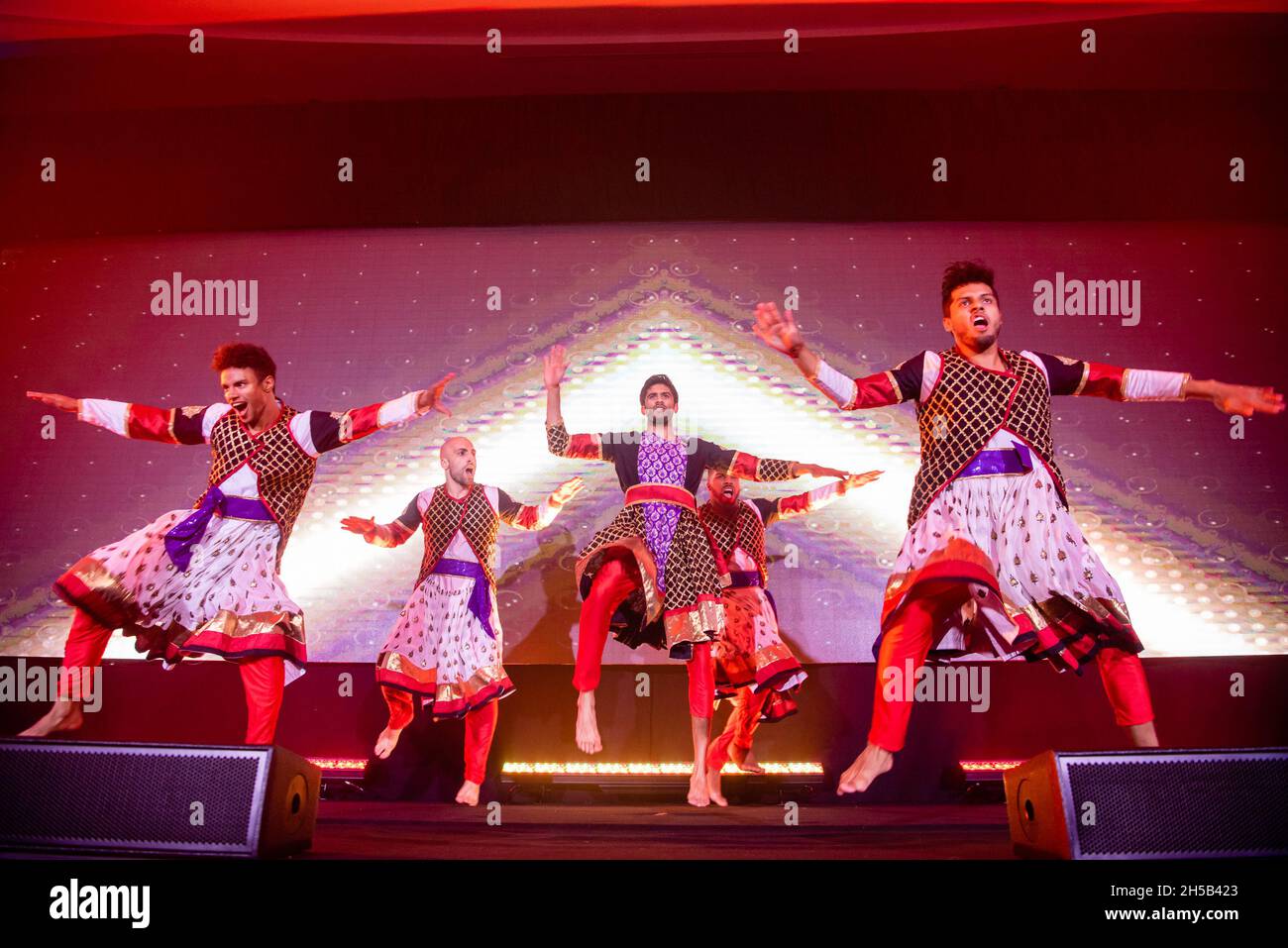 Performers dancing on stage with bodies creating silhouette shapes ...