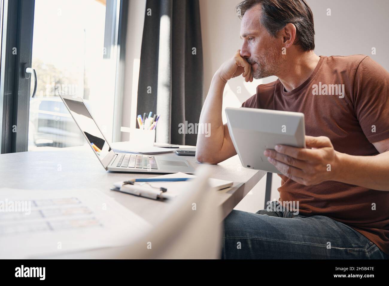 Sad businessman doing hard calculations at desk Stock Photo - Alamy