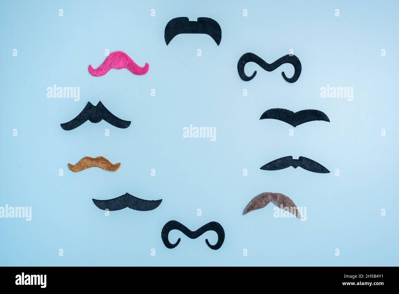Circle made with funny mustaches and space for text on blue Stock Photo ...